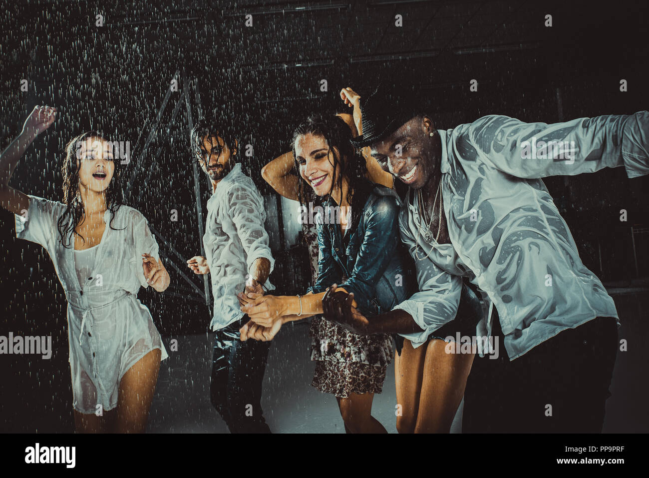 Group of friends dancing under the rain - Multiethnic people having ...