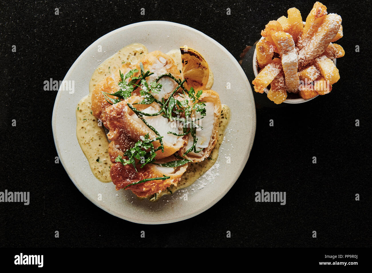 delicious crispy cod fish on white plate with chips in a bowl with ...