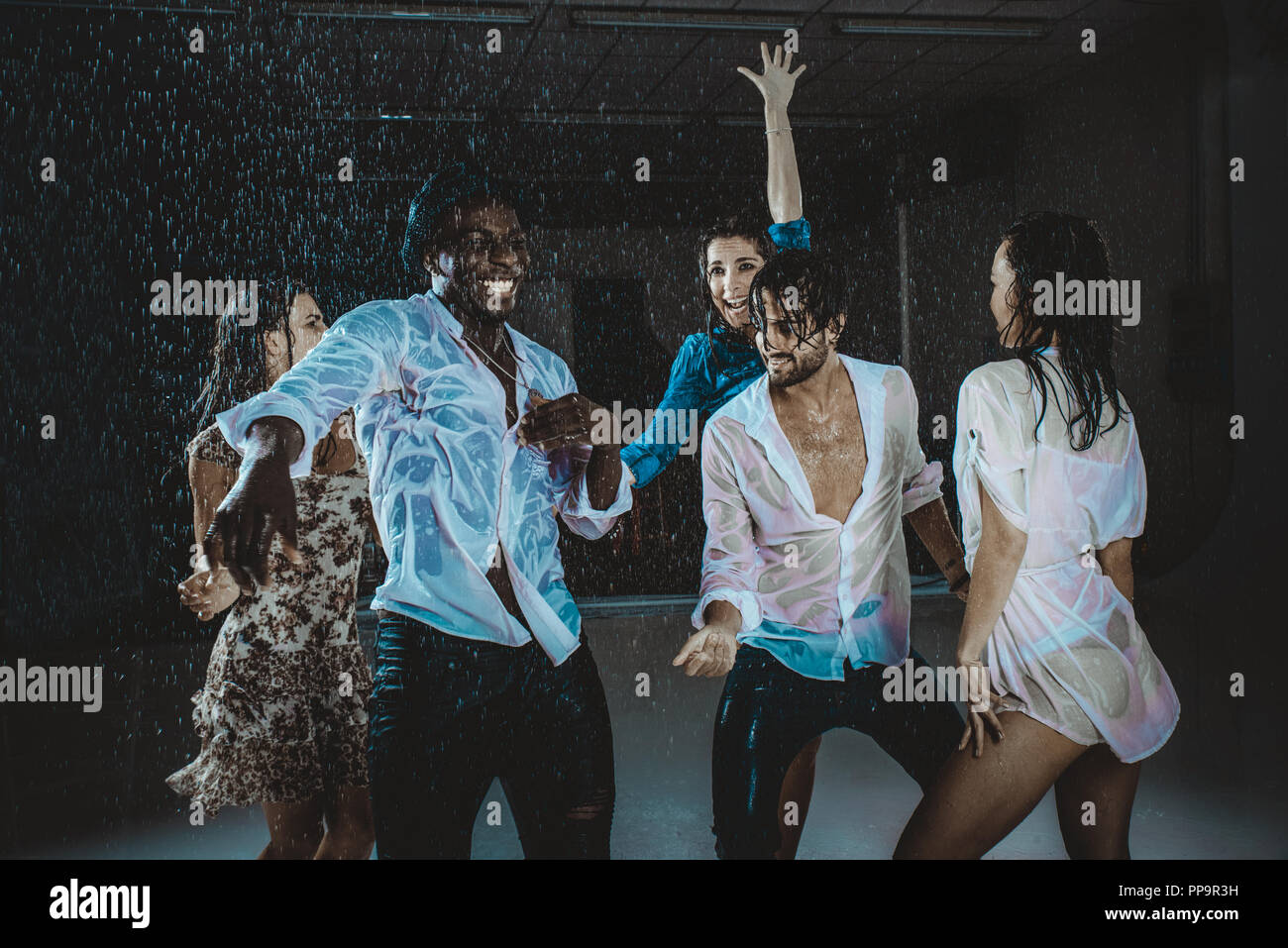 Group of friends dancing under the rain - Multiethnic people having ...