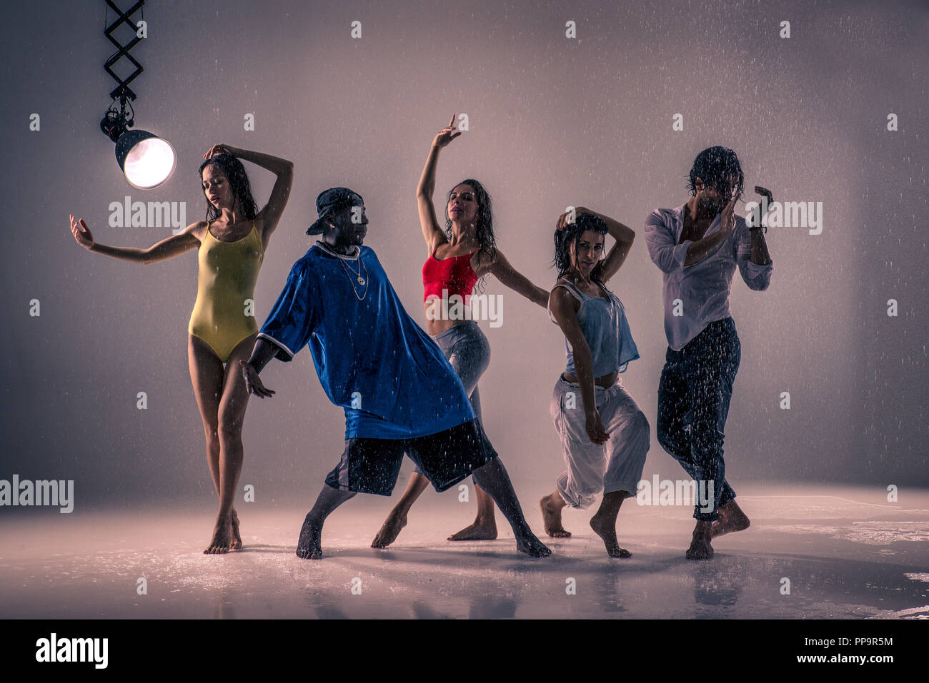Group of dancers dancing under the rain Stock Photo - Alamy