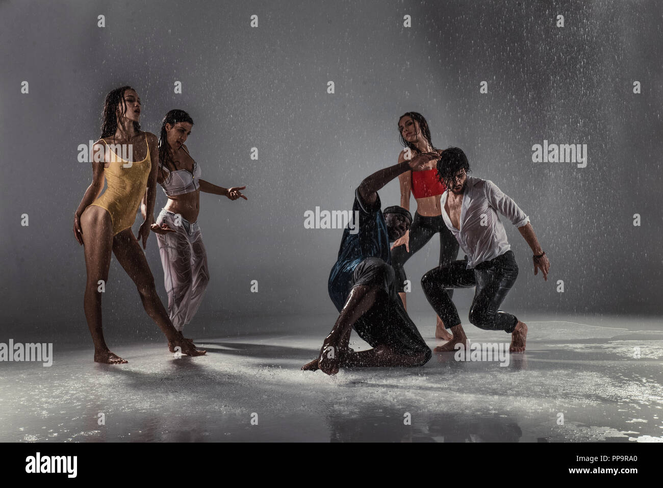 Group of dancers dancing under the rain Stock Photo - Alamy