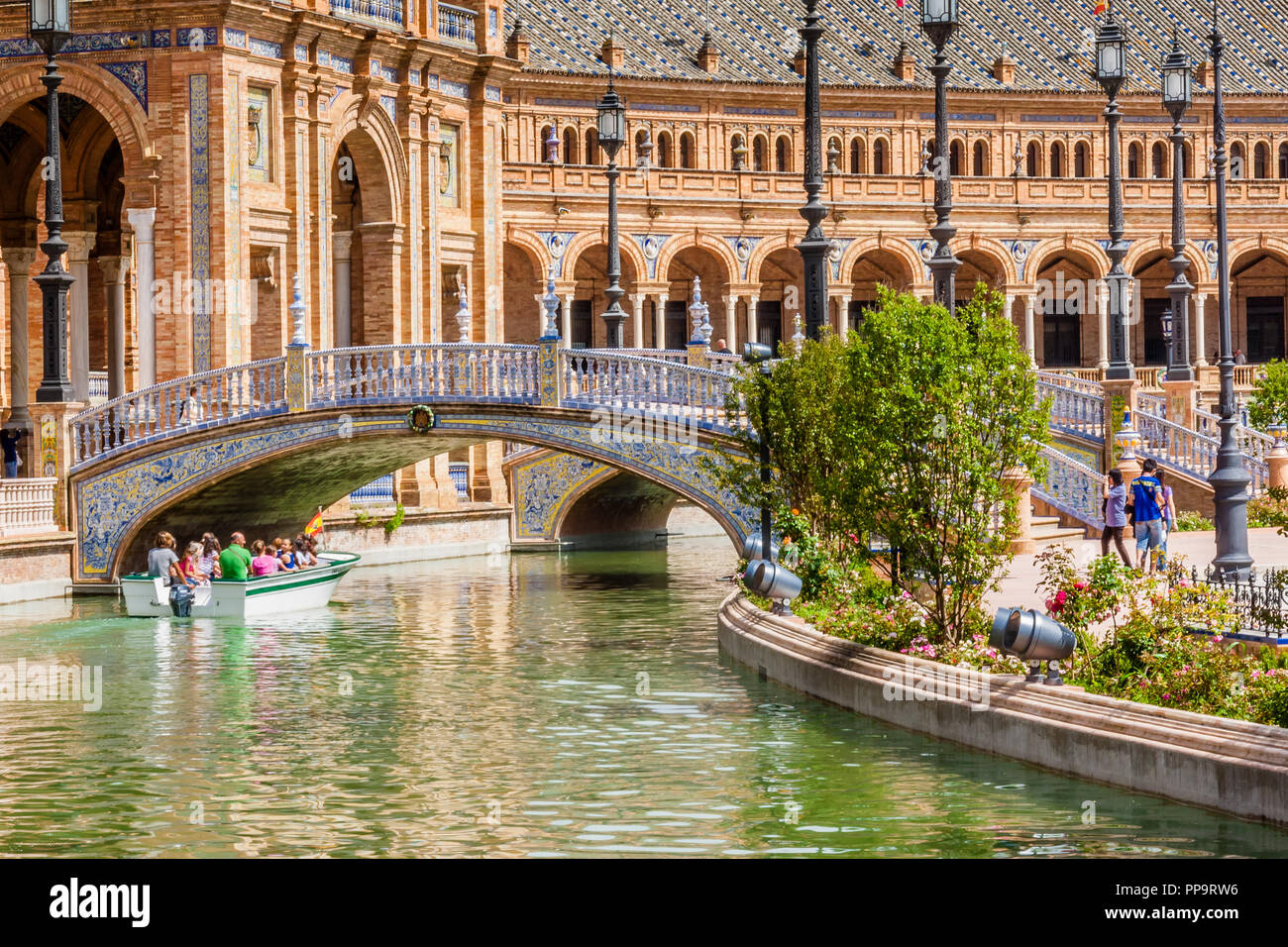 Tourists in a boat on the canal in Plaza de Espana, Seville, Spain ...