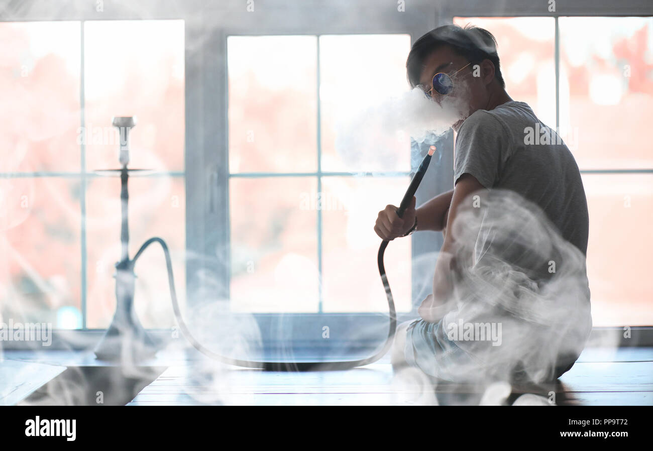 Man in sunglasses smoking a hookah Stock Photo - Alamy