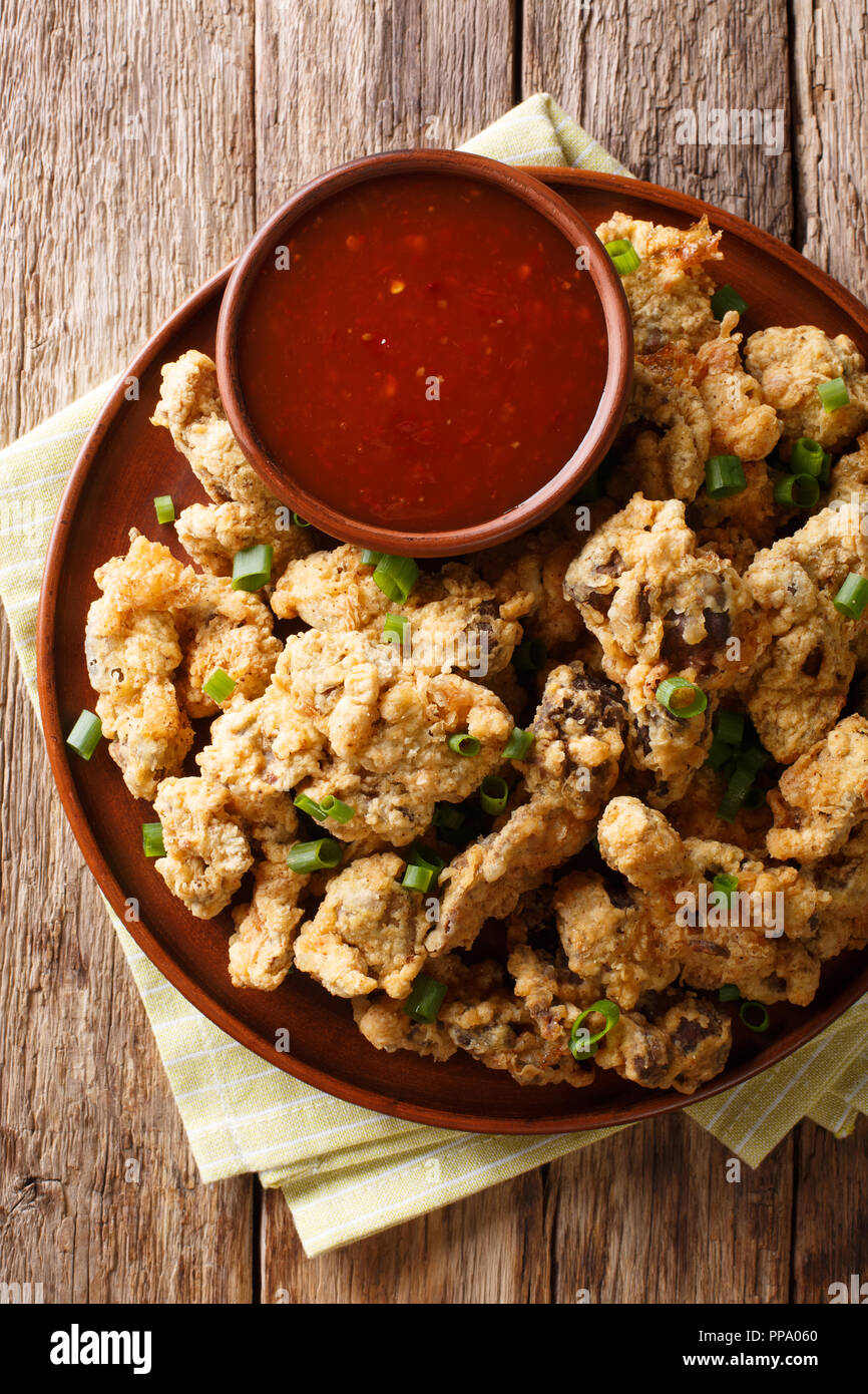 Fried chicken stomach in breaded, served with chili sauce close-up on a ...