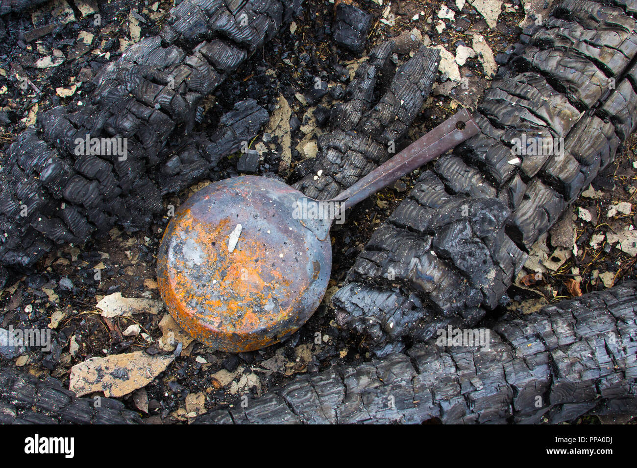 charred wooden parts of a burnt house and pan on a ground Stock Photo ...