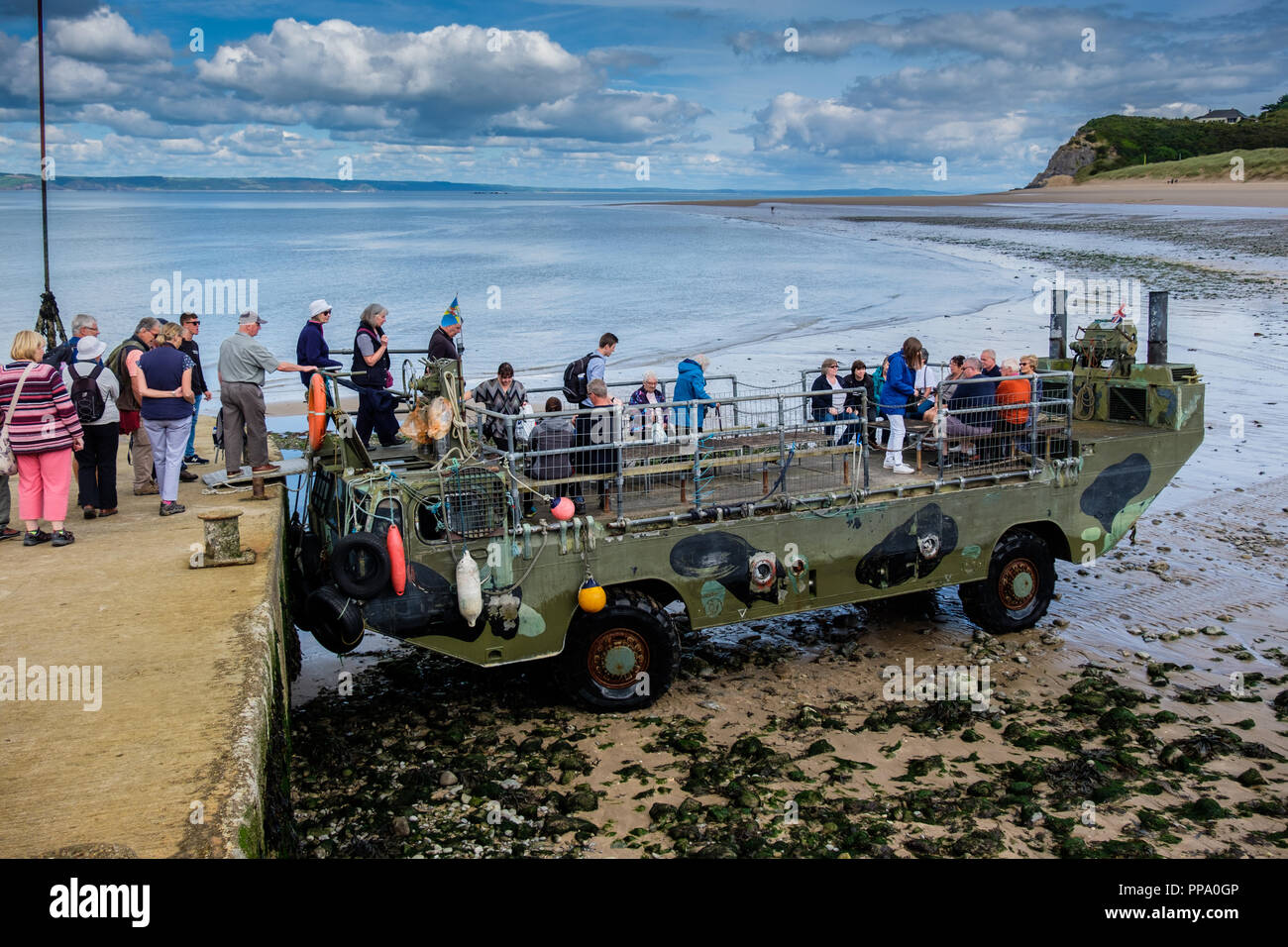 Amphibious vehicle shuttling people between jetty and boats at low tide ...