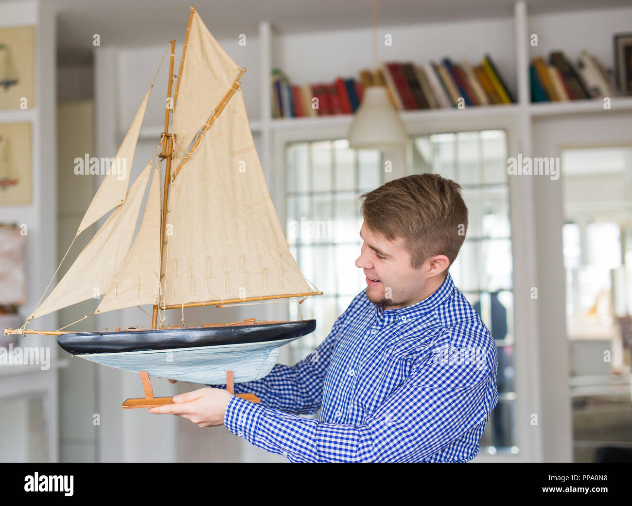 Hobby, collecting, ship and people concept - handsome man holding ...