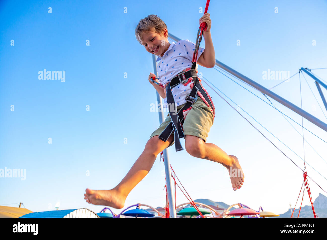 Smilling excited boy jumping on a trampoline with insurance Stock Photo ...