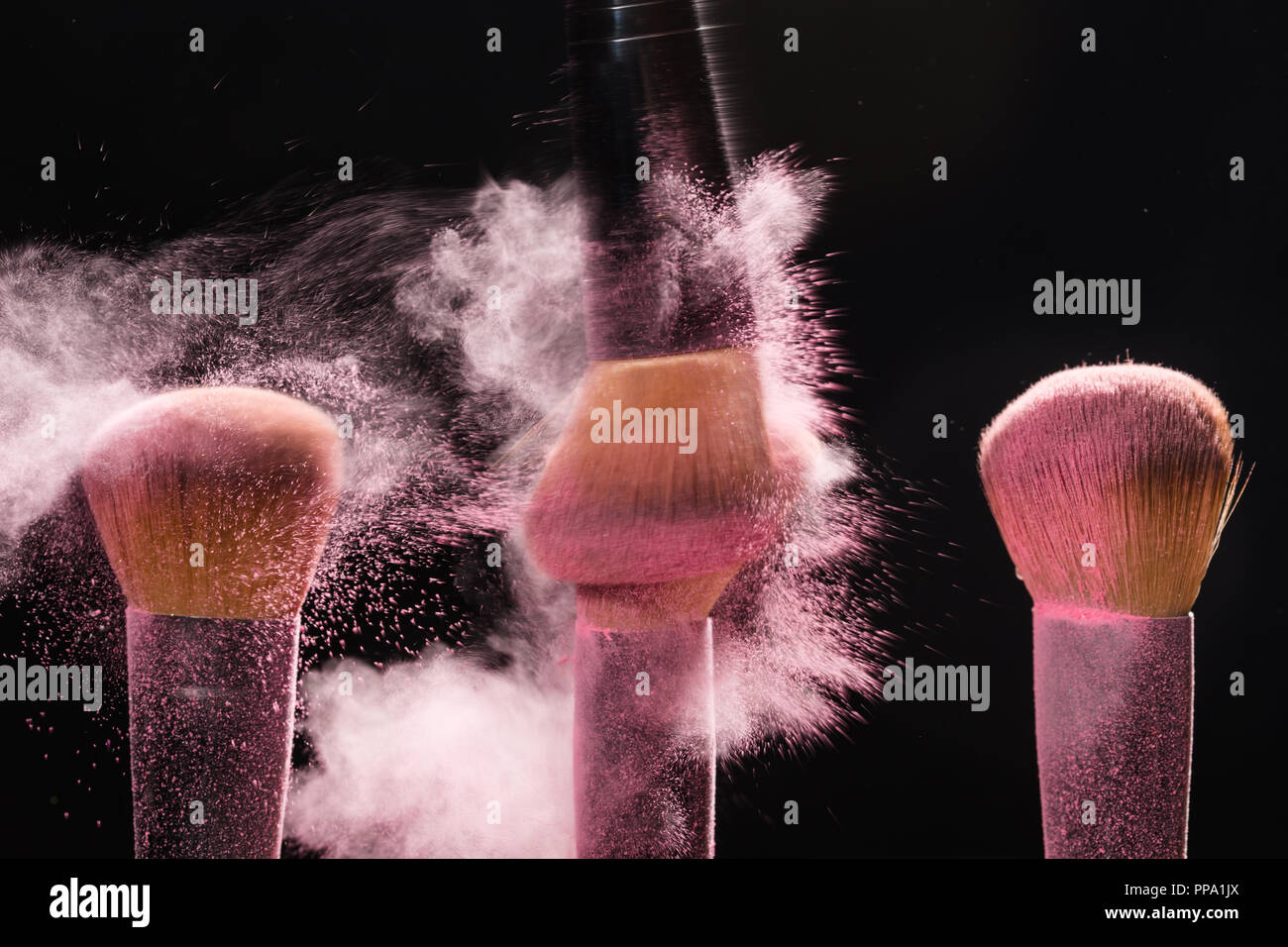 Mineral make up and objects concept - Three make up brushers in pink ...