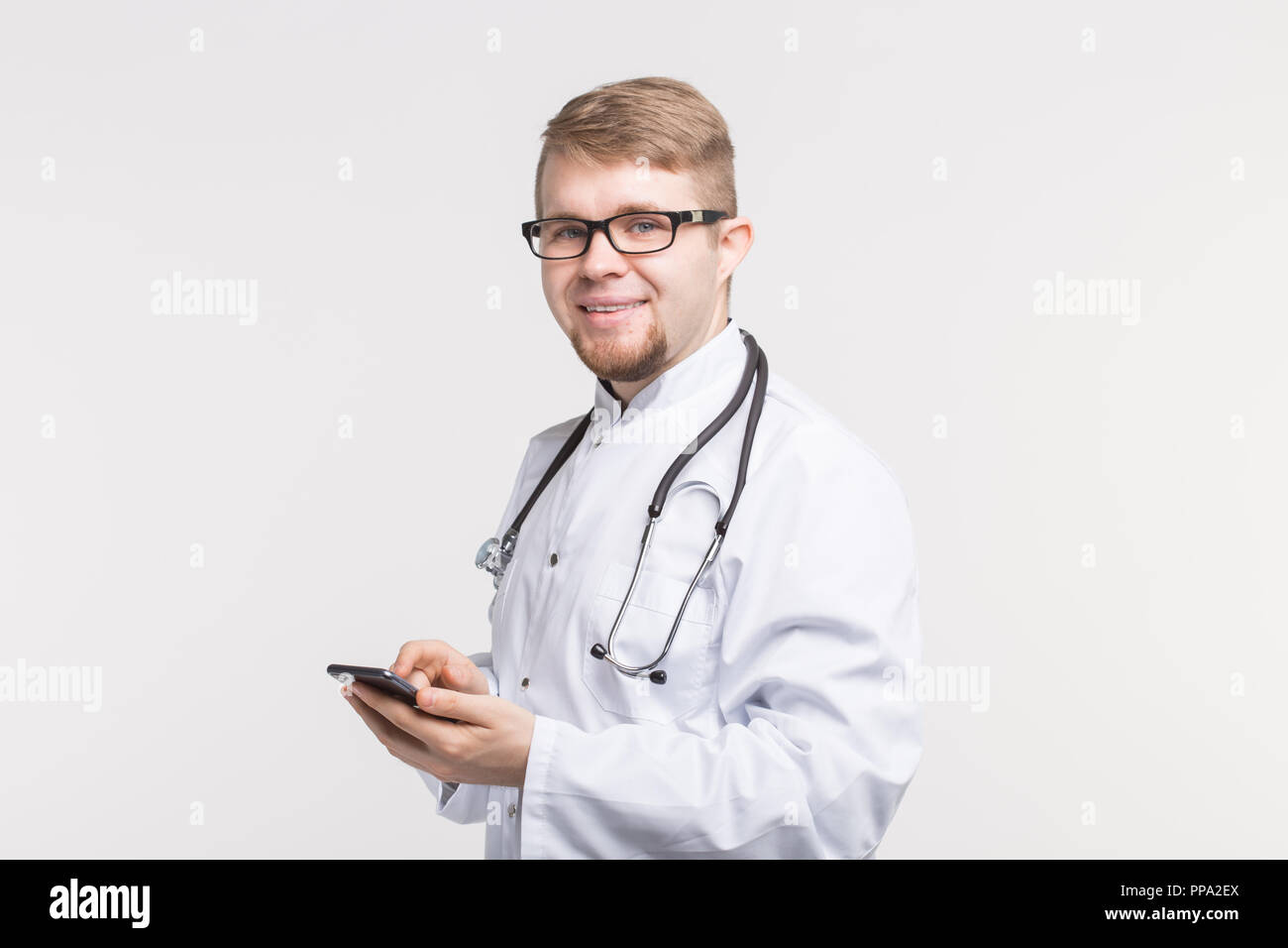 Portrait of male doctor with phone in hands on white background Stock ...