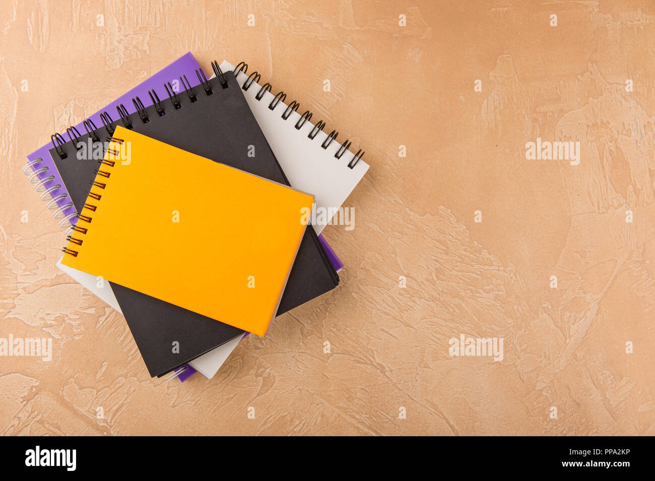 A stack of multi-colored notebooks on a spiral Stock Photo - Alamy