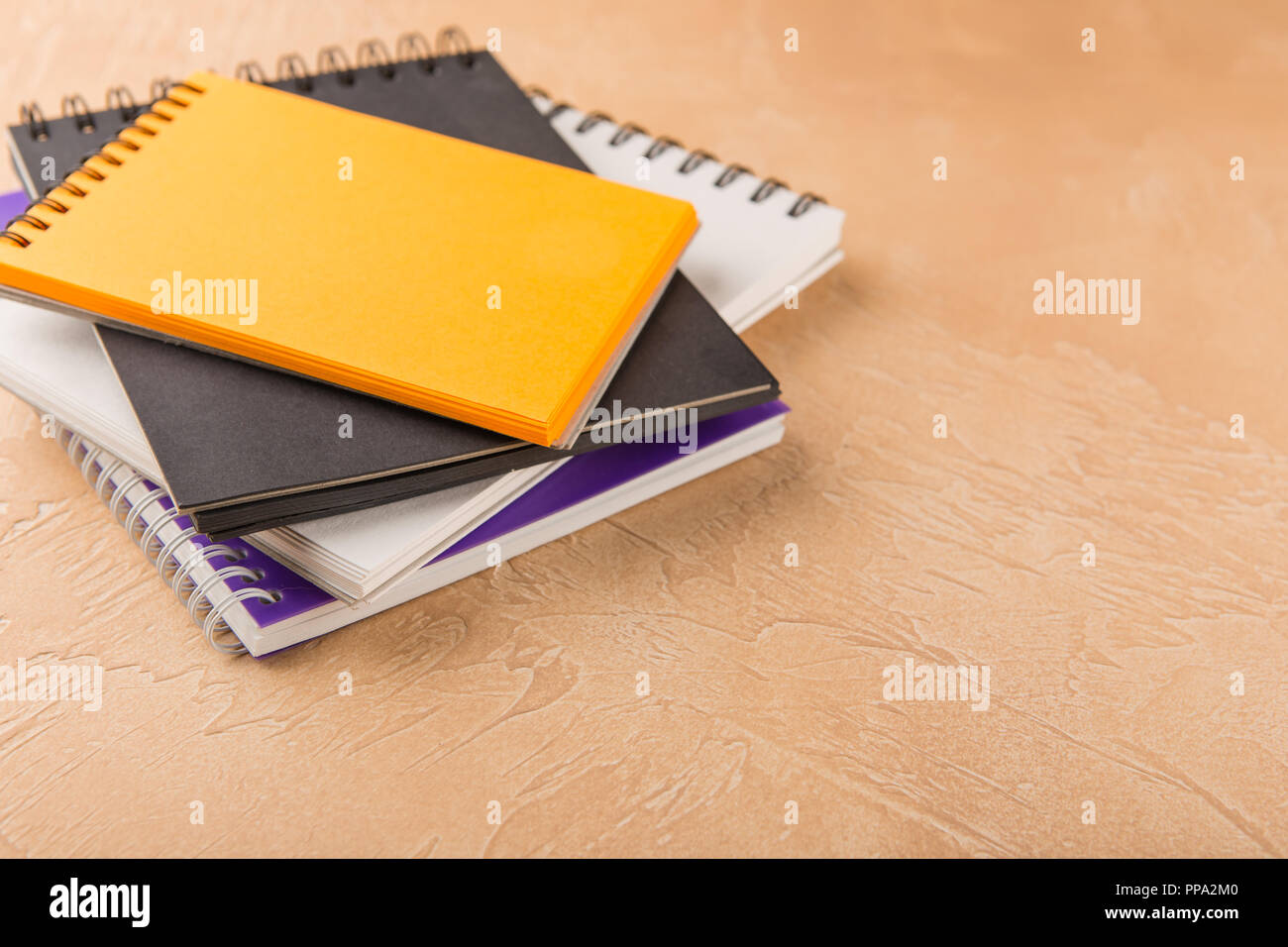 A stack of multi-colored notebooks on a spiral Stock Photo - Alamy