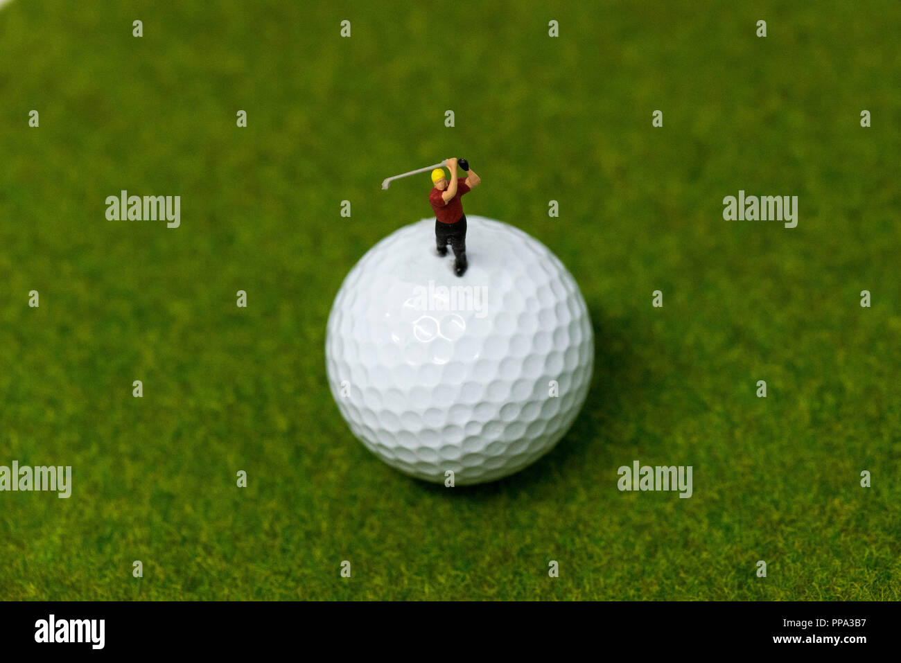golf ball with a miniature golfer on it Stock Photo - Alamy
