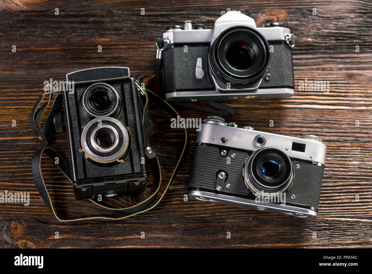 Old film camera, lenses and old exposure meter on a wooden background ...