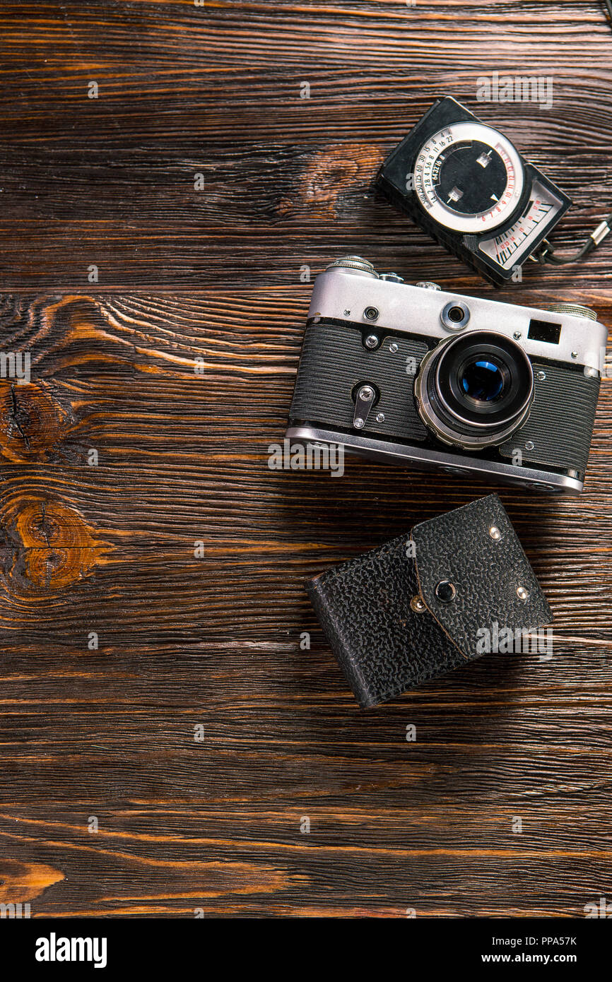 Old film camera, lenses and old exposure meter on a wooden background ...
