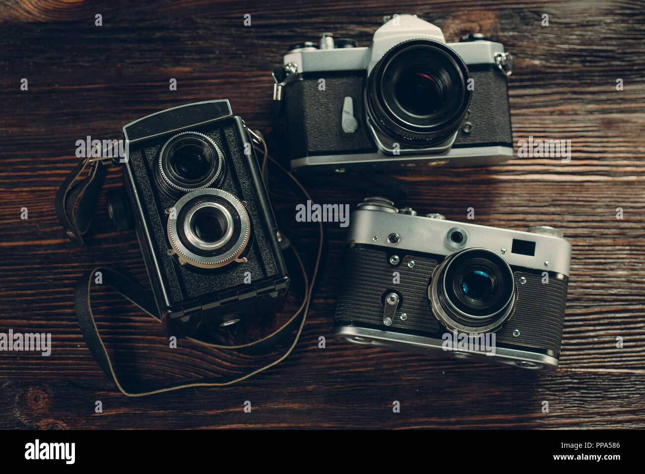 Old film camera, lenses and old exposure meter on a wooden background ...