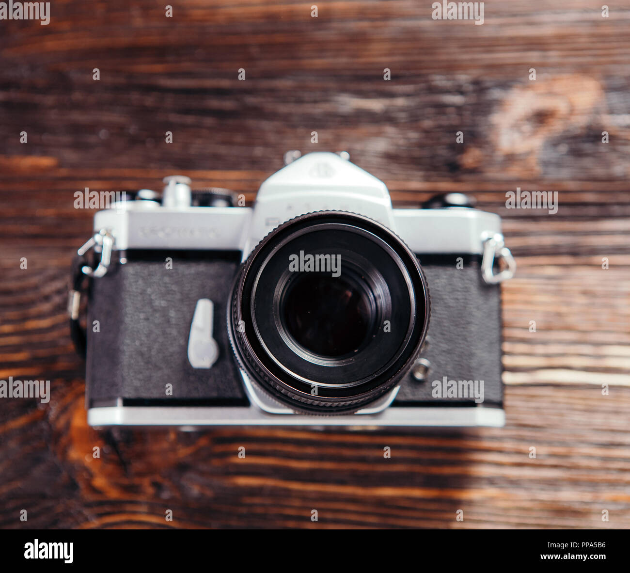 Old film camera, lenses and old exposure meter on a wooden background ...