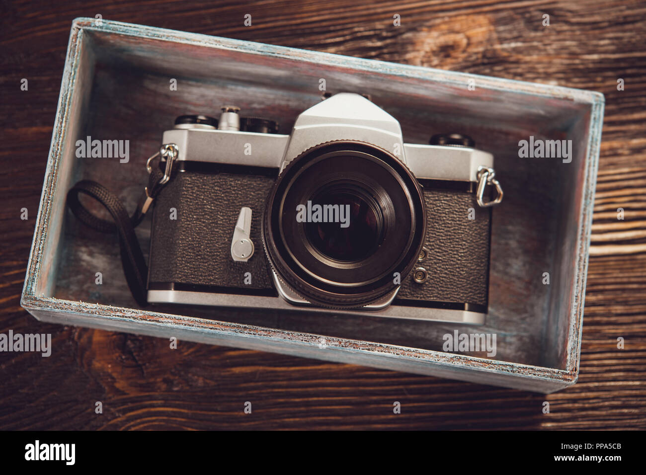 Old film camera, lenses and old exposure meter on a wooden background ...
