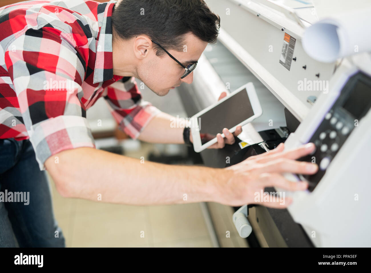 Man with tablet using printer Stock Photo - Alamy