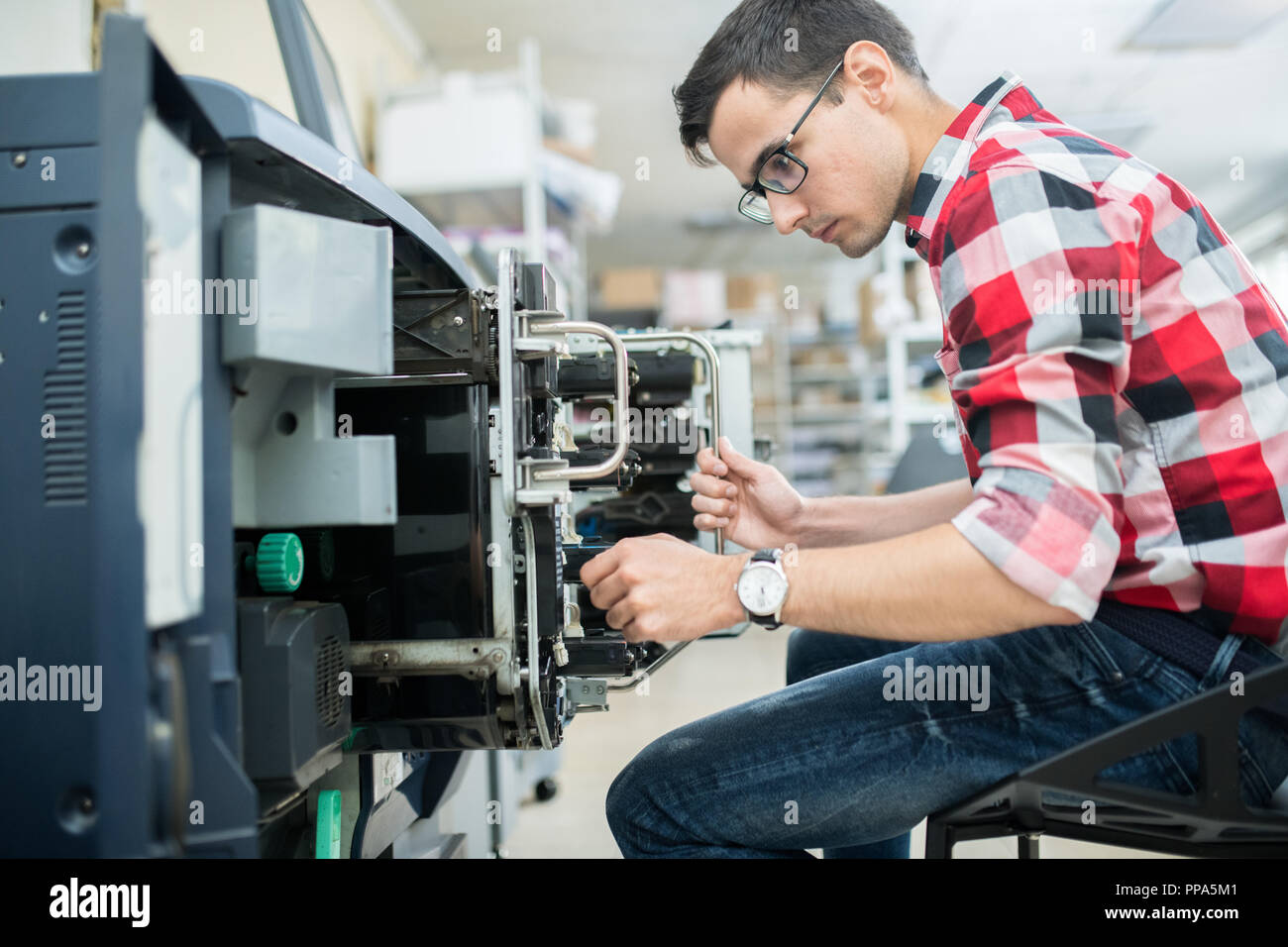 Casual man working with printing machine Stock Photo - Alamy