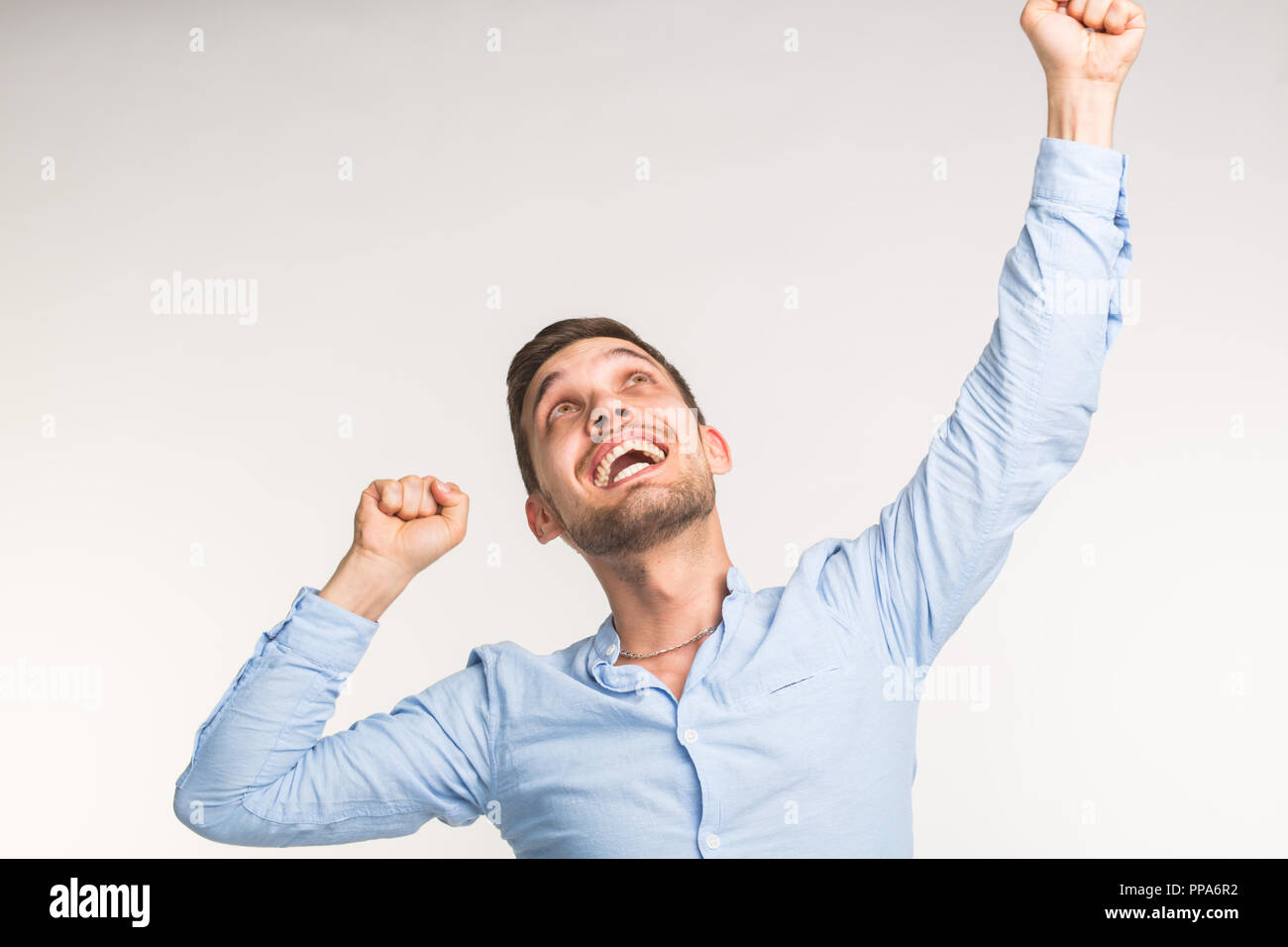 Victory and power concept - Handsome man raising one hand above his ...