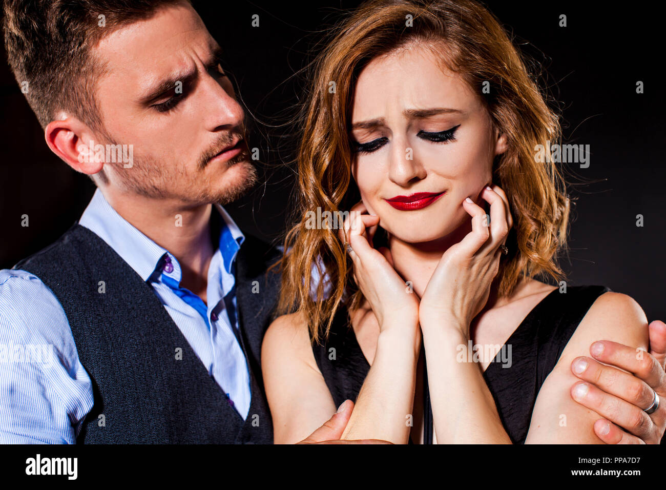 Portrait of young emotional couple on the black background Stock Photo ...
