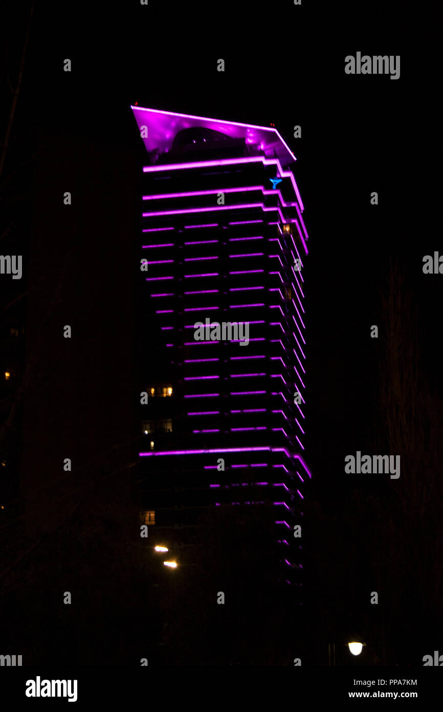 Skyscraper building silhouette illuminated with fluorescent magenta ...