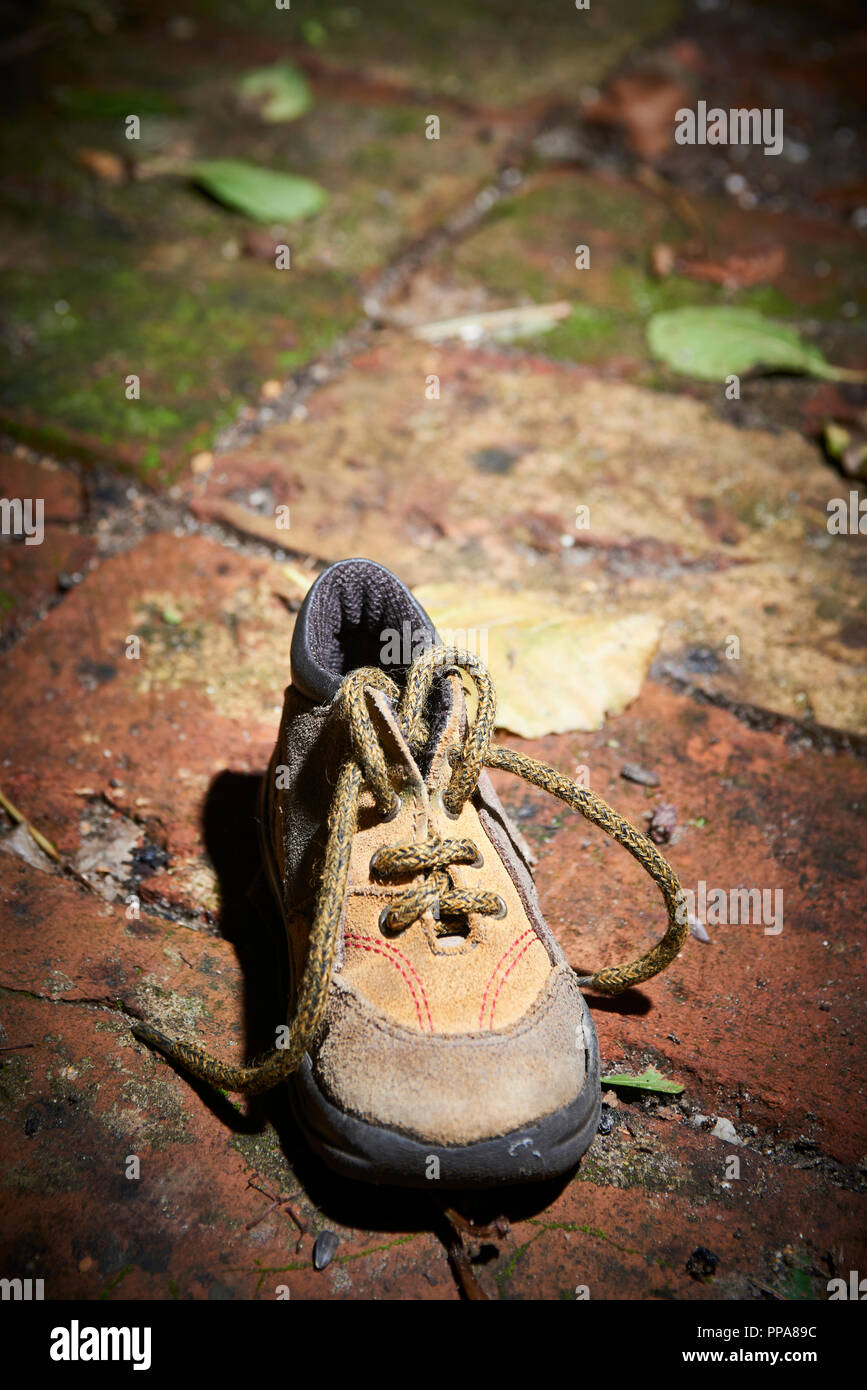 Abandoned baby shoe lying on an old brick floor. Lost children's shoes ...