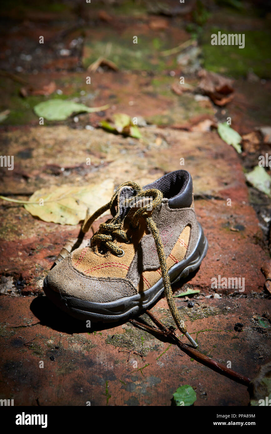 Abandoned baby shoe lying on an old brick floor. Lost children's shoes ...