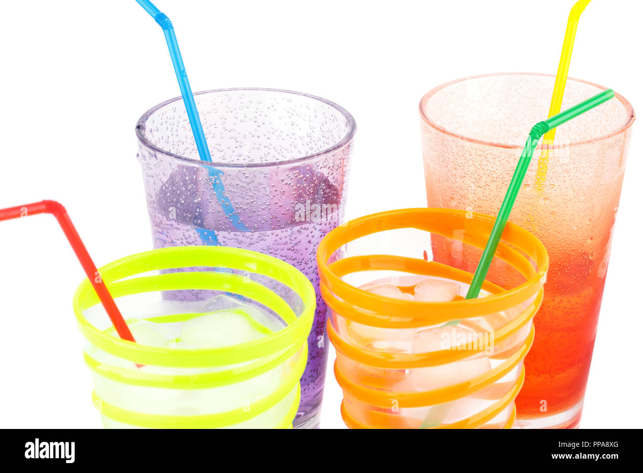 Plastic glasses with water, ice cubes and straws on white background ...
