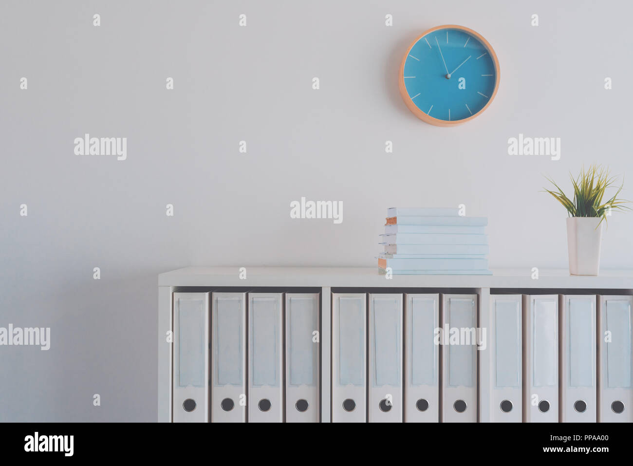 Modern bright business office interior detail depicting wall clock and ...