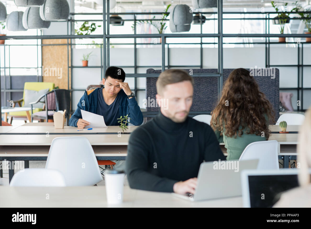 Group of people working in open space office, focus on young Asian man ...