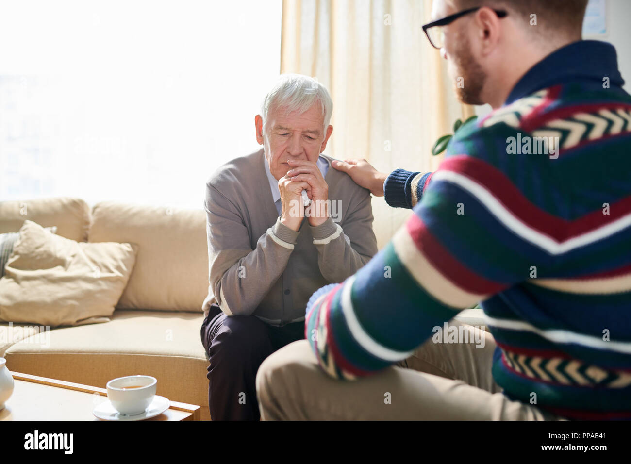 Back view portrait of male psychologist consoling depressed senior man ...