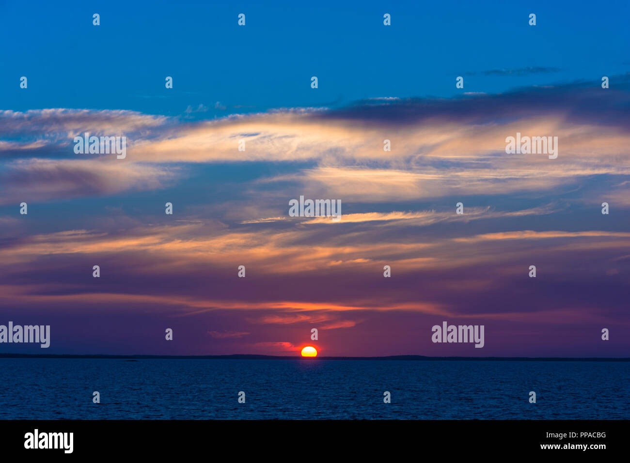 Bright beautiful sunset at the White sea with dark blue water and ...