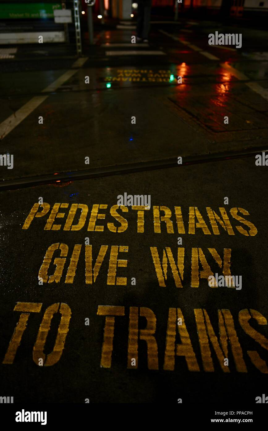 Pedestrians give way to trams sign on the footpath hi-res stock ...