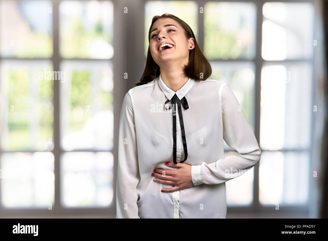 Attractive woman bursting in laugh Stock Photo - Alamy