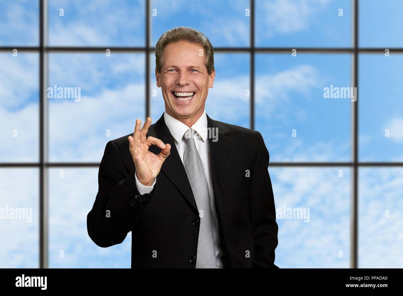 Happy businessman showing ok sign Stock Photo - Alamy