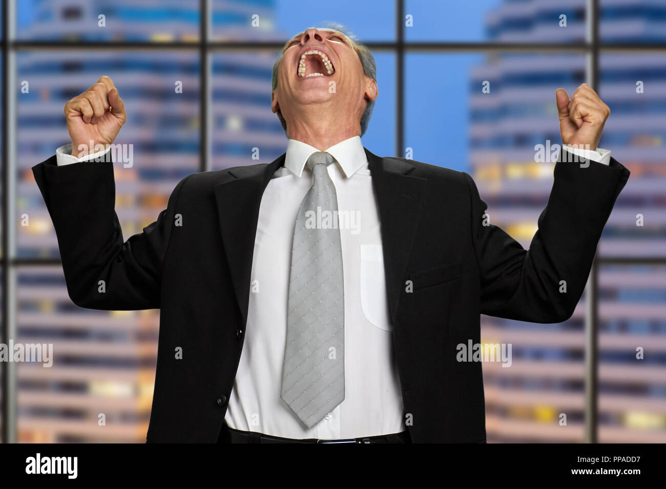 Businessman expressing victory with raised hands Stock Photo - Alamy