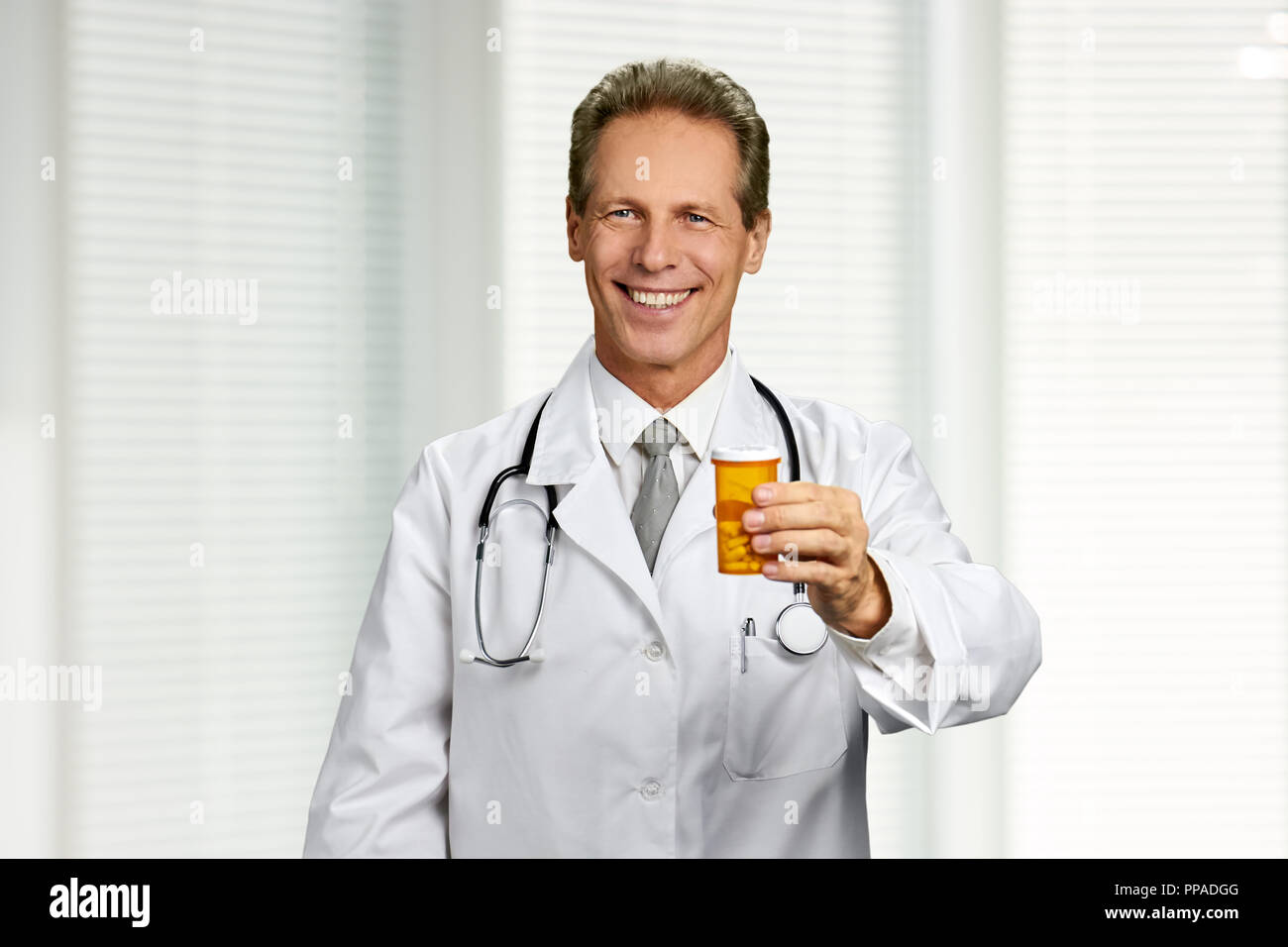 Happy caucasian doctor showing container hi-res stock photography and ...