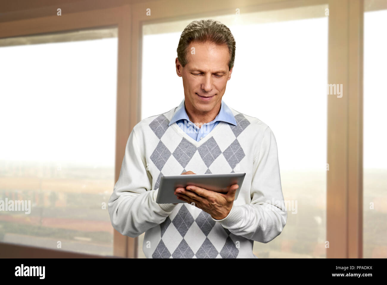 Mature manager using pc tablet Stock Photo - Alamy