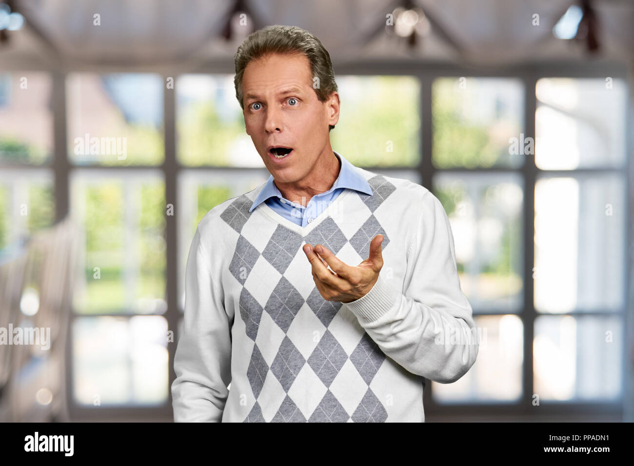 Shocked mature man on blurred background Stock Photo - Alamy