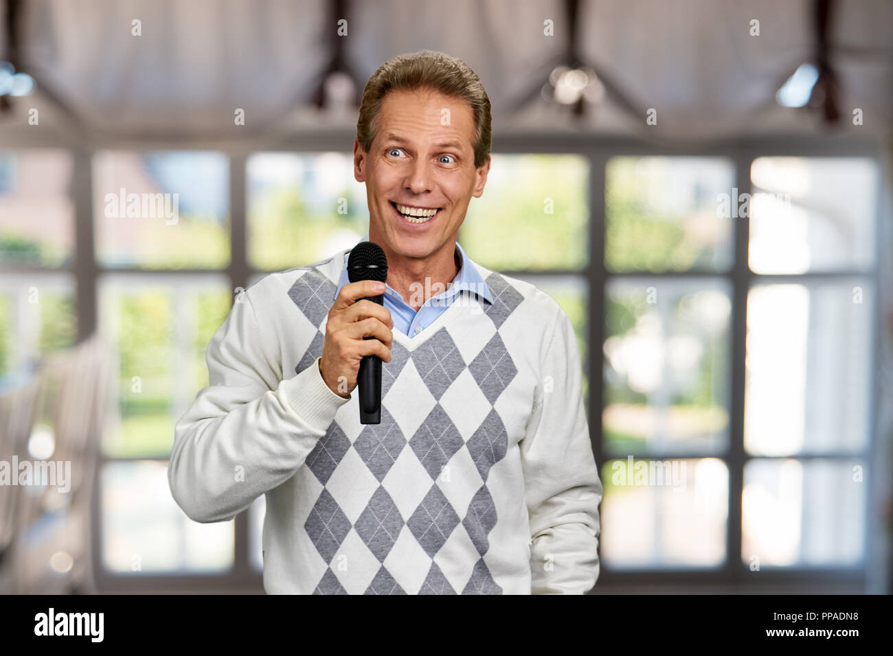 Happy smiling man holding microphone Stock Photo - Alamy