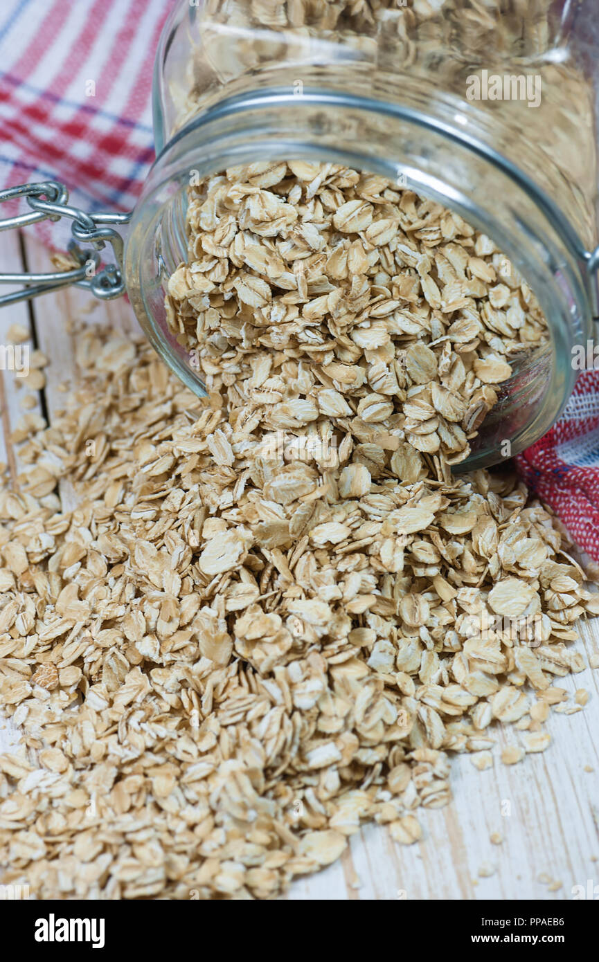 Oat flakes spilling from the glass jar Stock Photo - Alamy