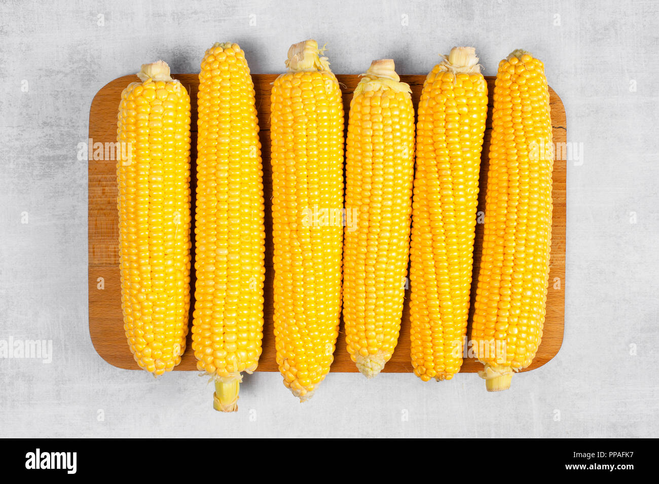 Pilled fresh corn cobs on the textured grey table, top view Stock Photo ...