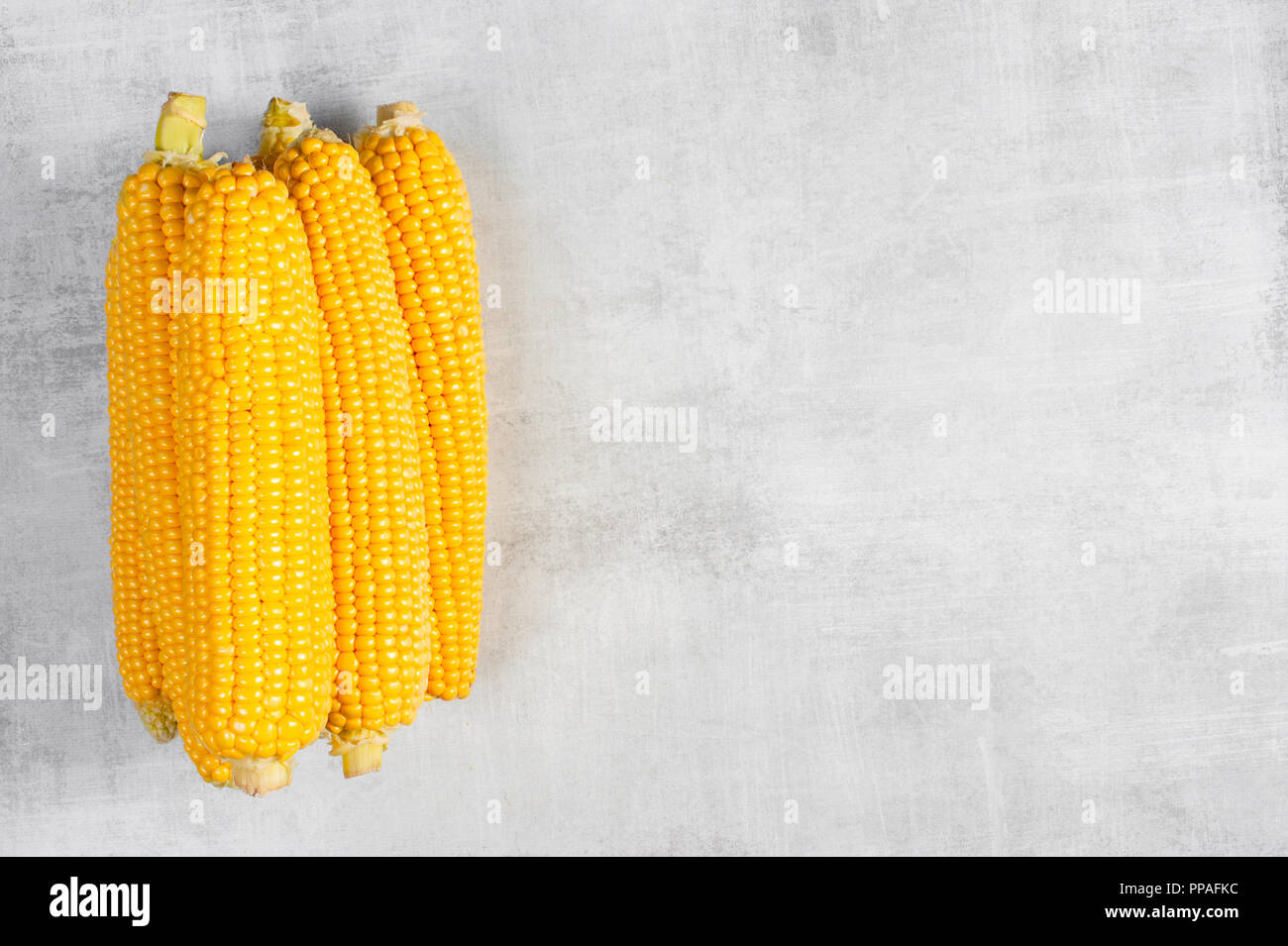 Pilled fresh corn cobs on the textured grey table, top view Stock Photo ...