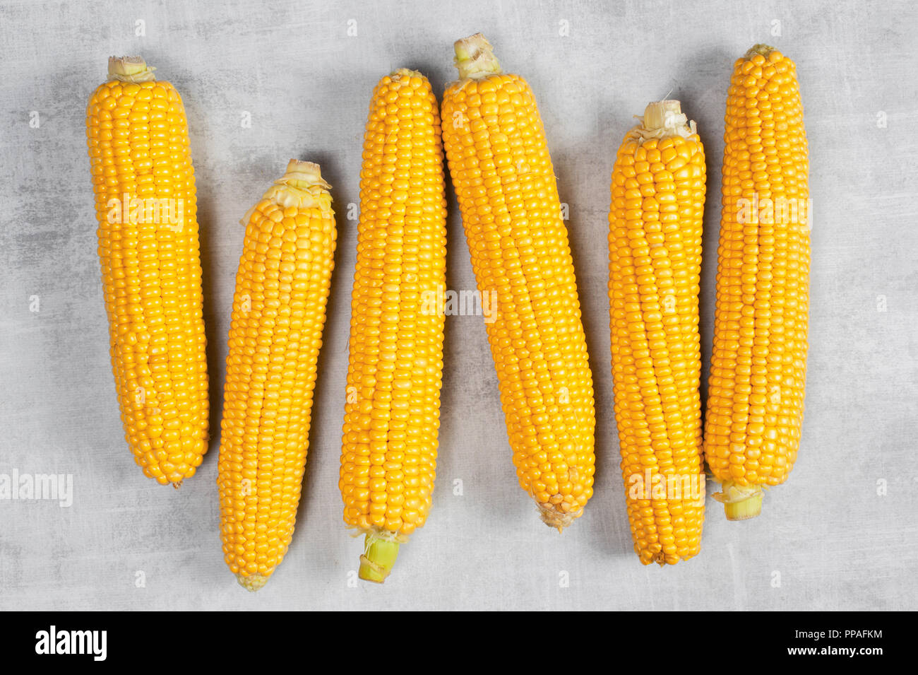 Pilled fresh corn cobs on the textured grey table, top view Stock Photo ...