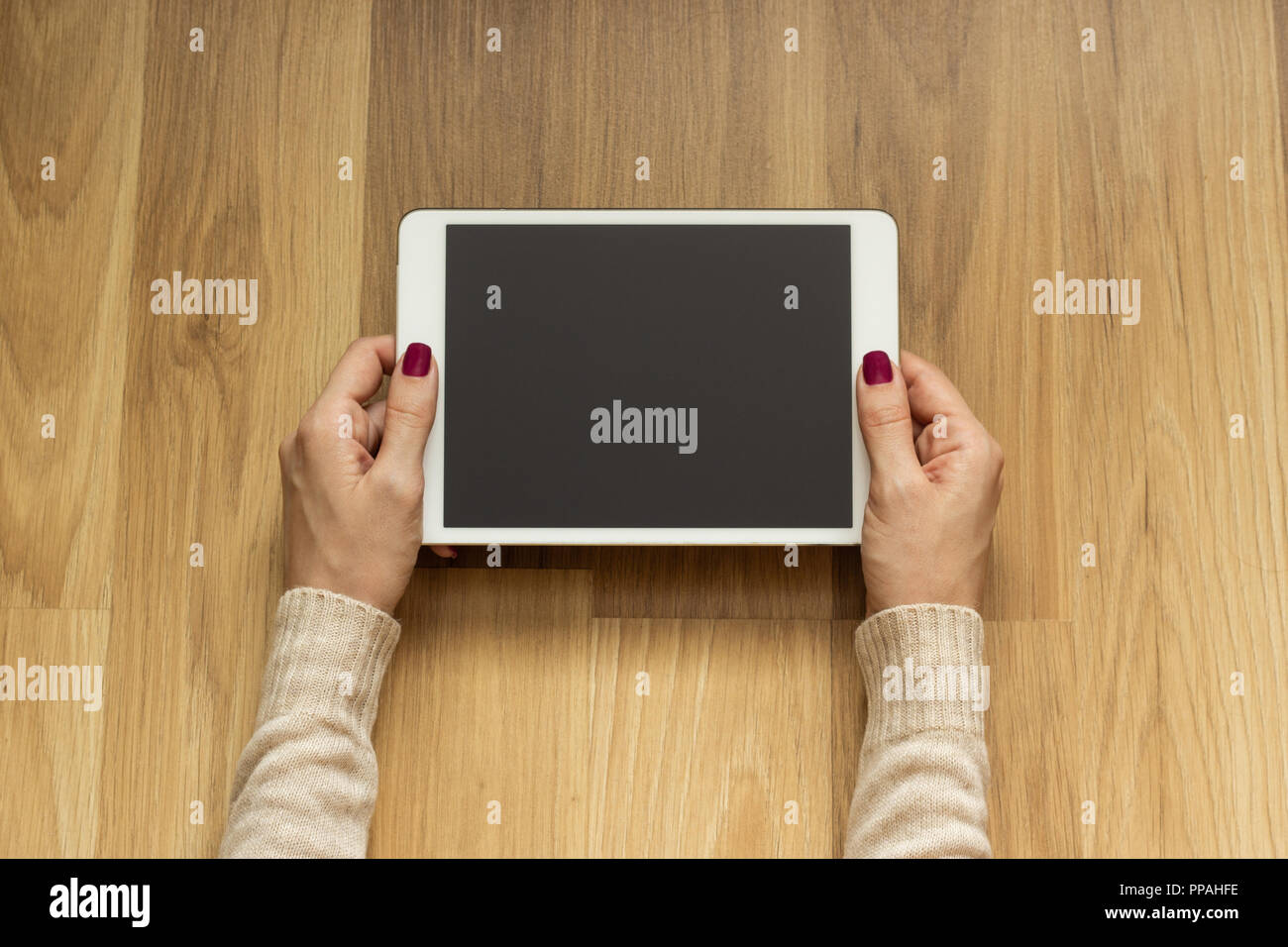Girl lying on the floor holding a tablet Stock Photo - Alamy