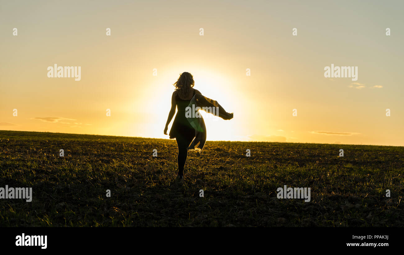 Girl Walking into The Sunset Stock Photo - Alamy