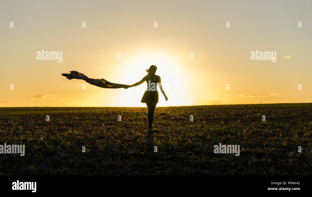 Girl Walking into The Sunset Stock Photo - Alamy