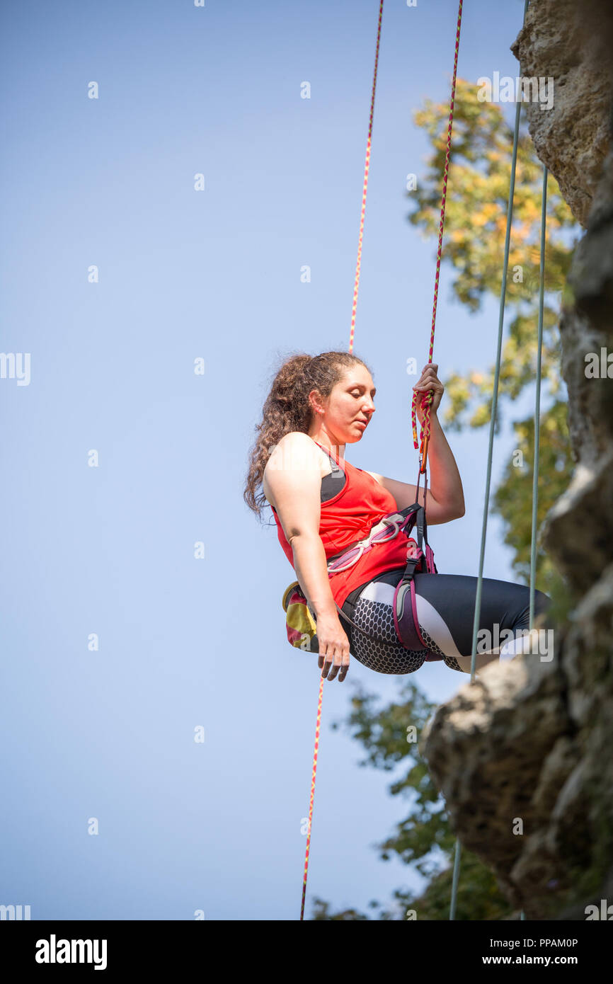 Photo of athlete woman clambering over rock Stock Photo - Alamy